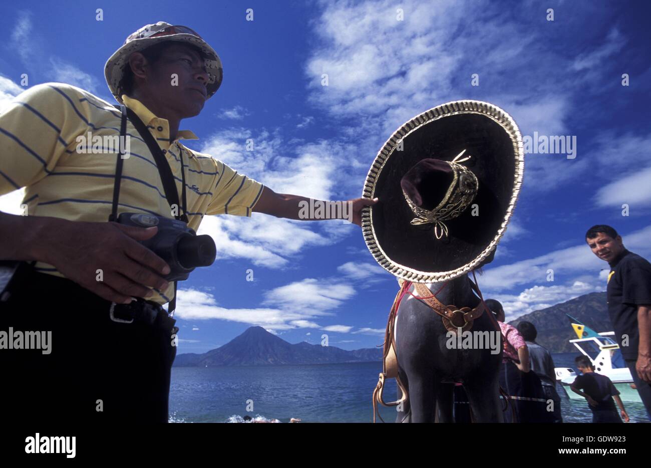 People at the coast of Lake Atitlan mit the Volcanos of Toliman and San ...