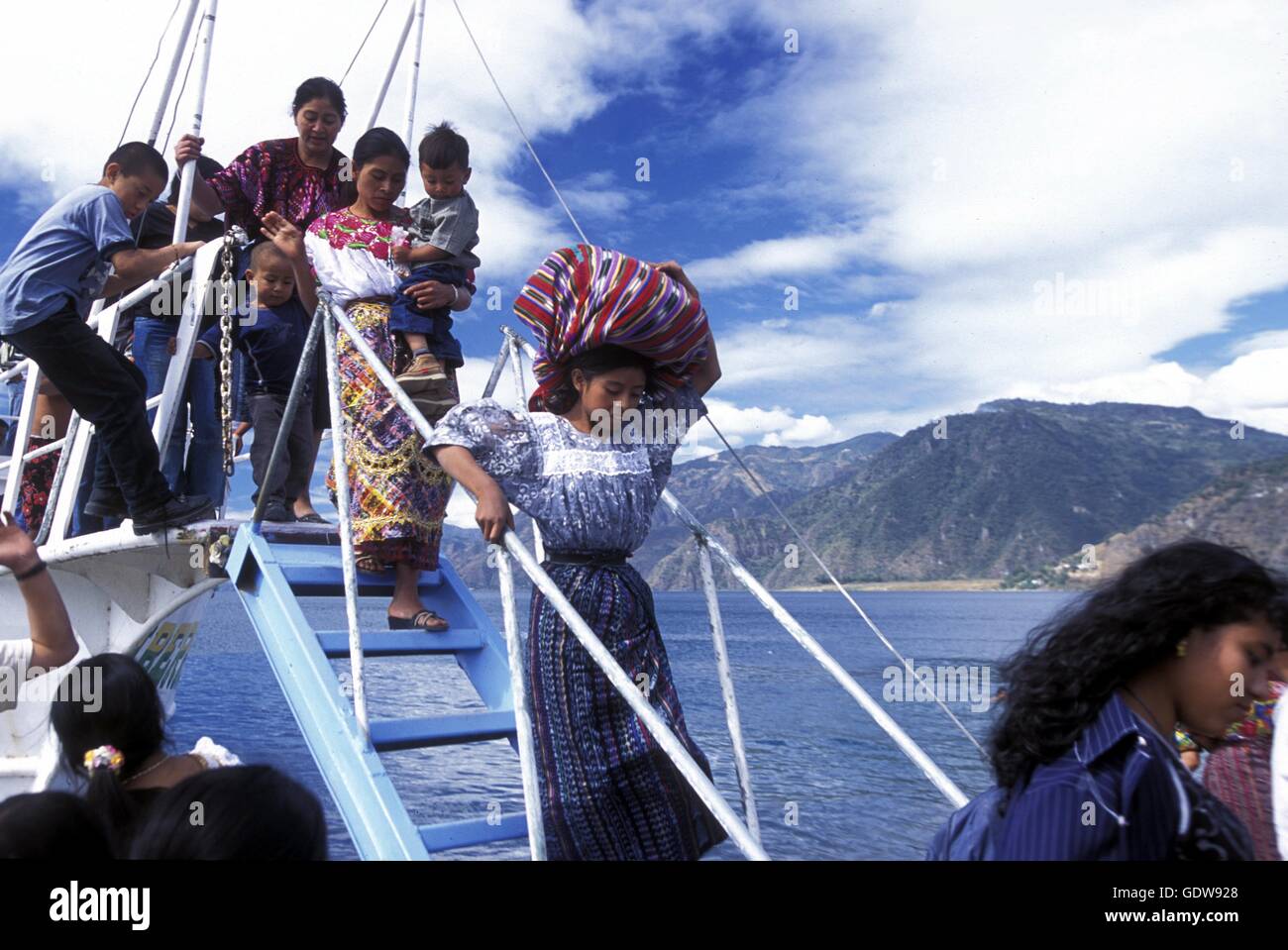 People at the coast of Lake Atitlan mit the Volcanos of Toliman and San ...
