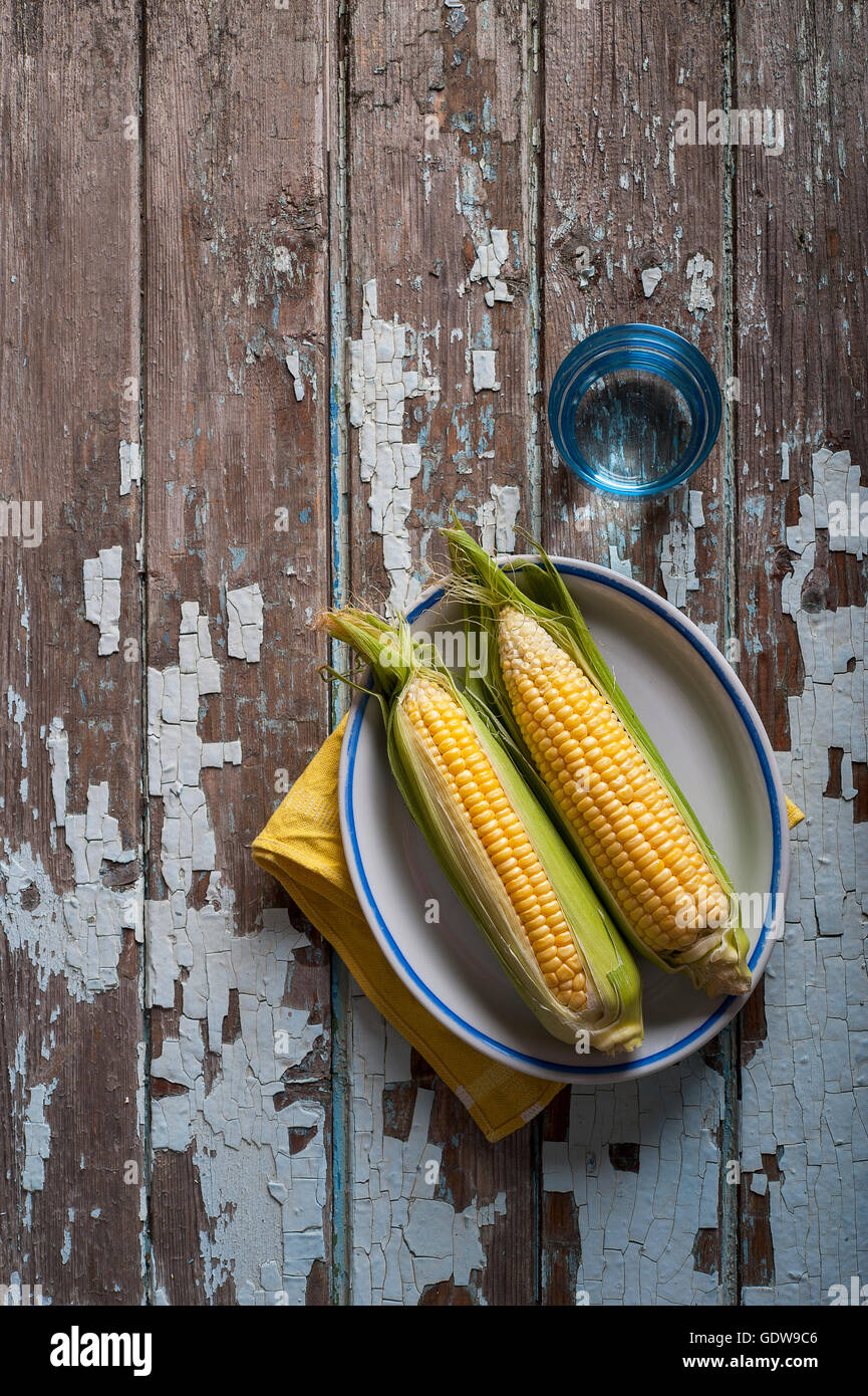 Raw corn on a wood table Stock Photo - Alamy