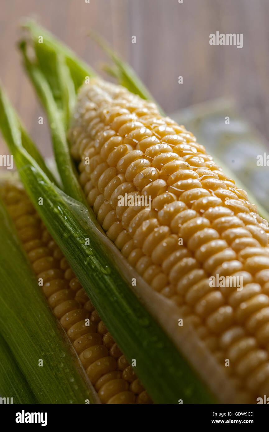 Raw corn on a wood table Stock Photo - Alamy
