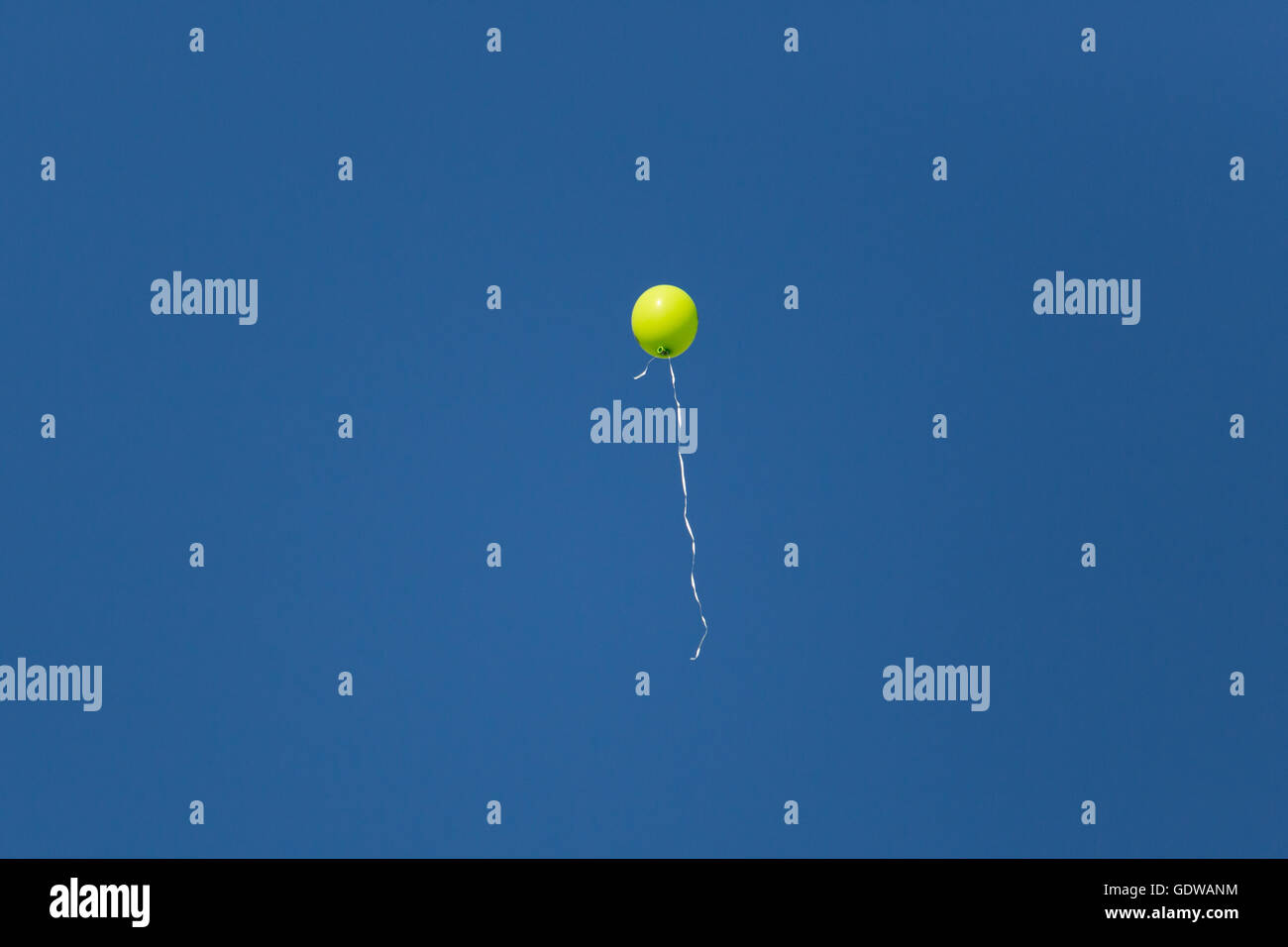 Yellow balloon flying in the blue sky Stock Photo - Alamy