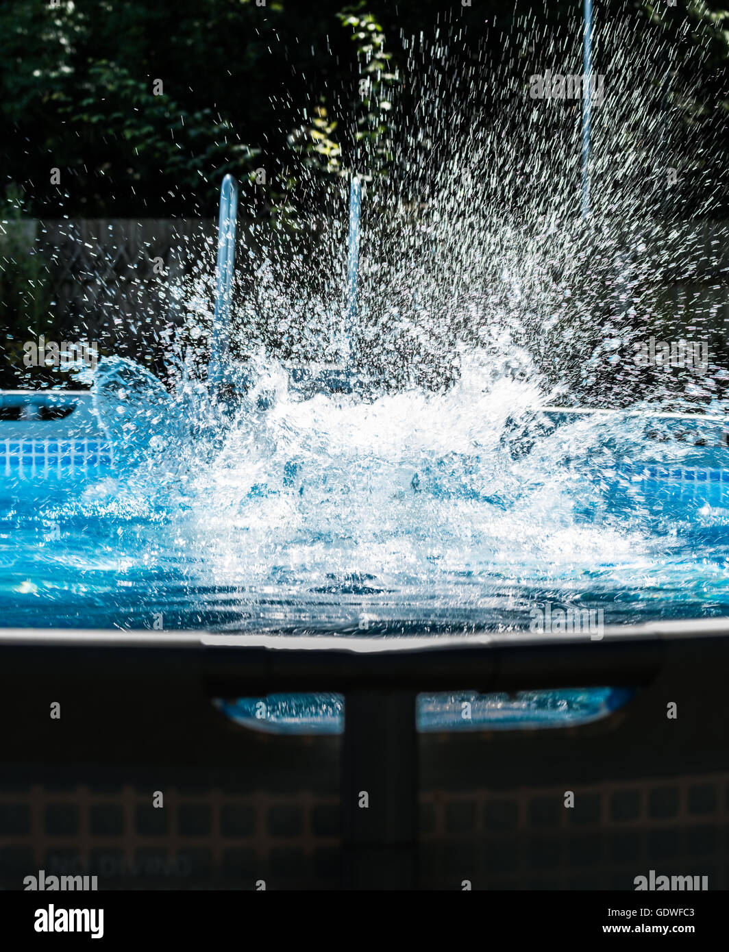 Splash created by a jump into an above ground pool Stock Photo - Alamy