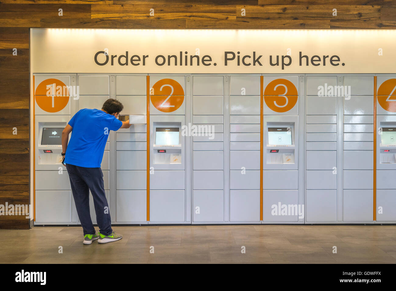 Man reaching into an ecommerce locker to get a package he ordered ...