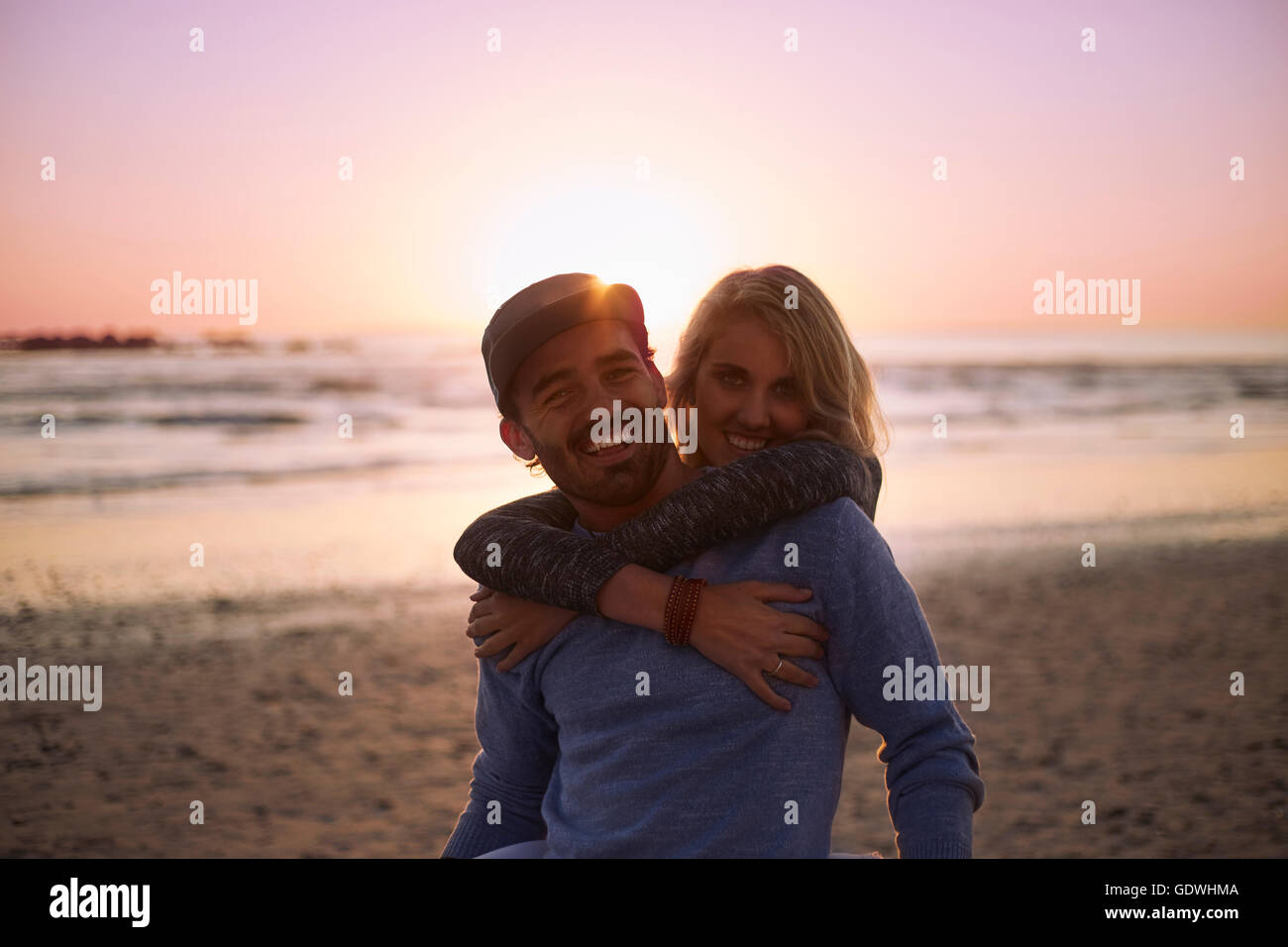 Portrait smiling couple hugging on sunset beach Stock Photo - Alamy
