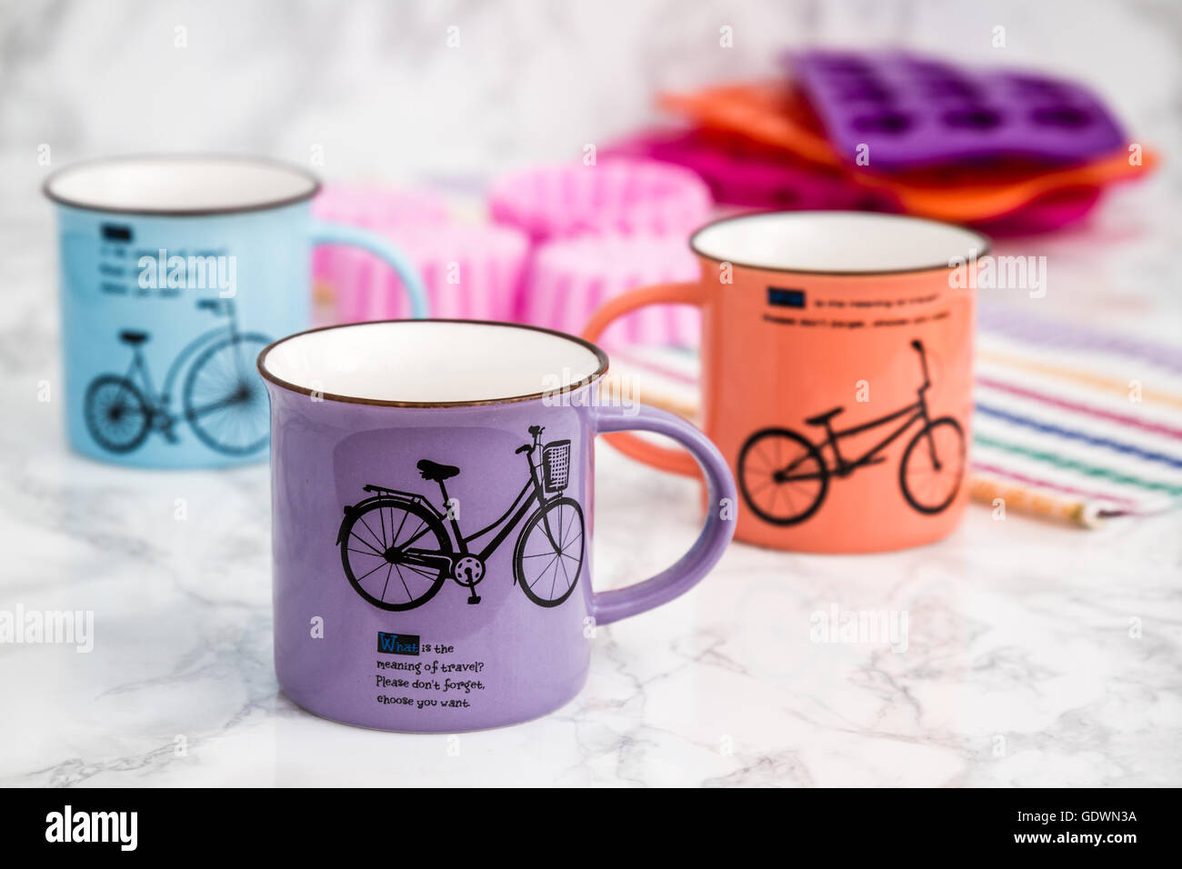 Colorful modern ceramic mugs with bicycle design on white marble ...