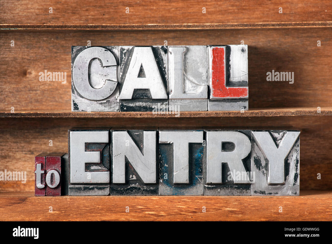 call to entry phrase made from metallic letterpress type on wooden tray ...