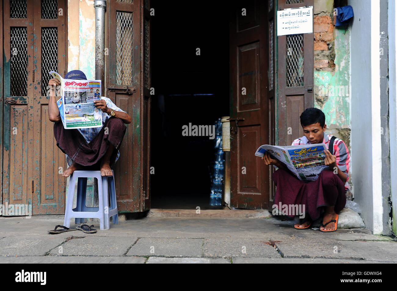 Two people reading the newspaper Stock Photo - Alamy