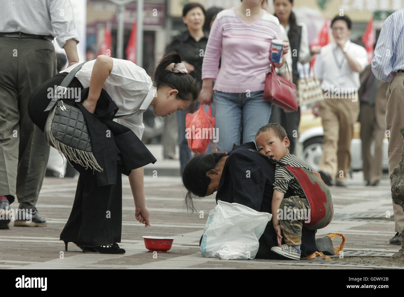 A Chinese beggar begs with a kid on a street Stock Photo - Alamy