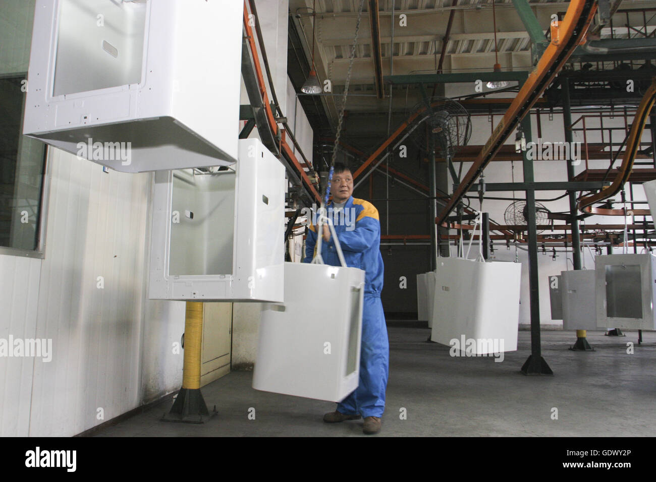 A worker tends refrigerator at a production line Stock Photo - Alamy