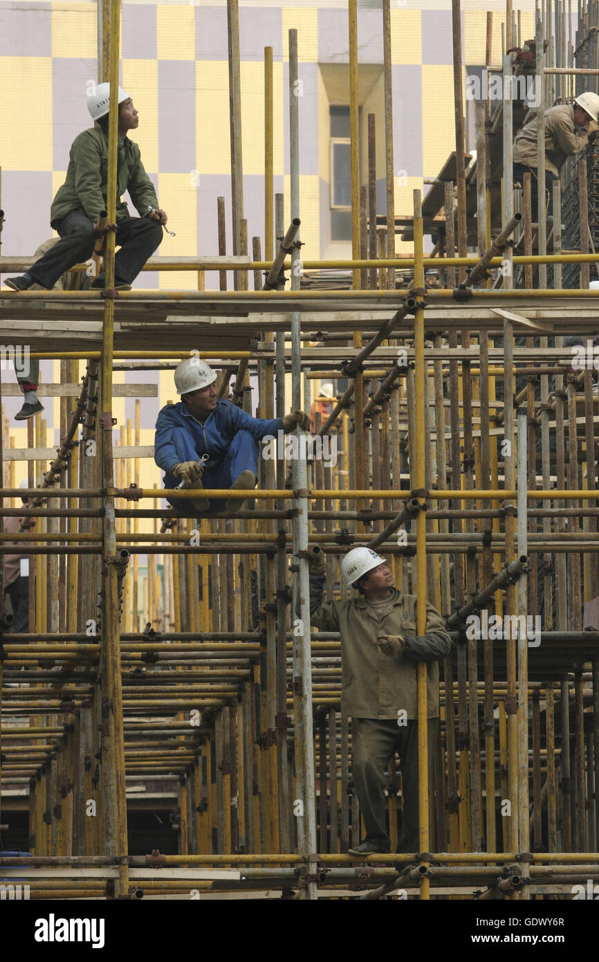 Workers stand on scaffoldiing at a construction site Stock Photo - Alamy