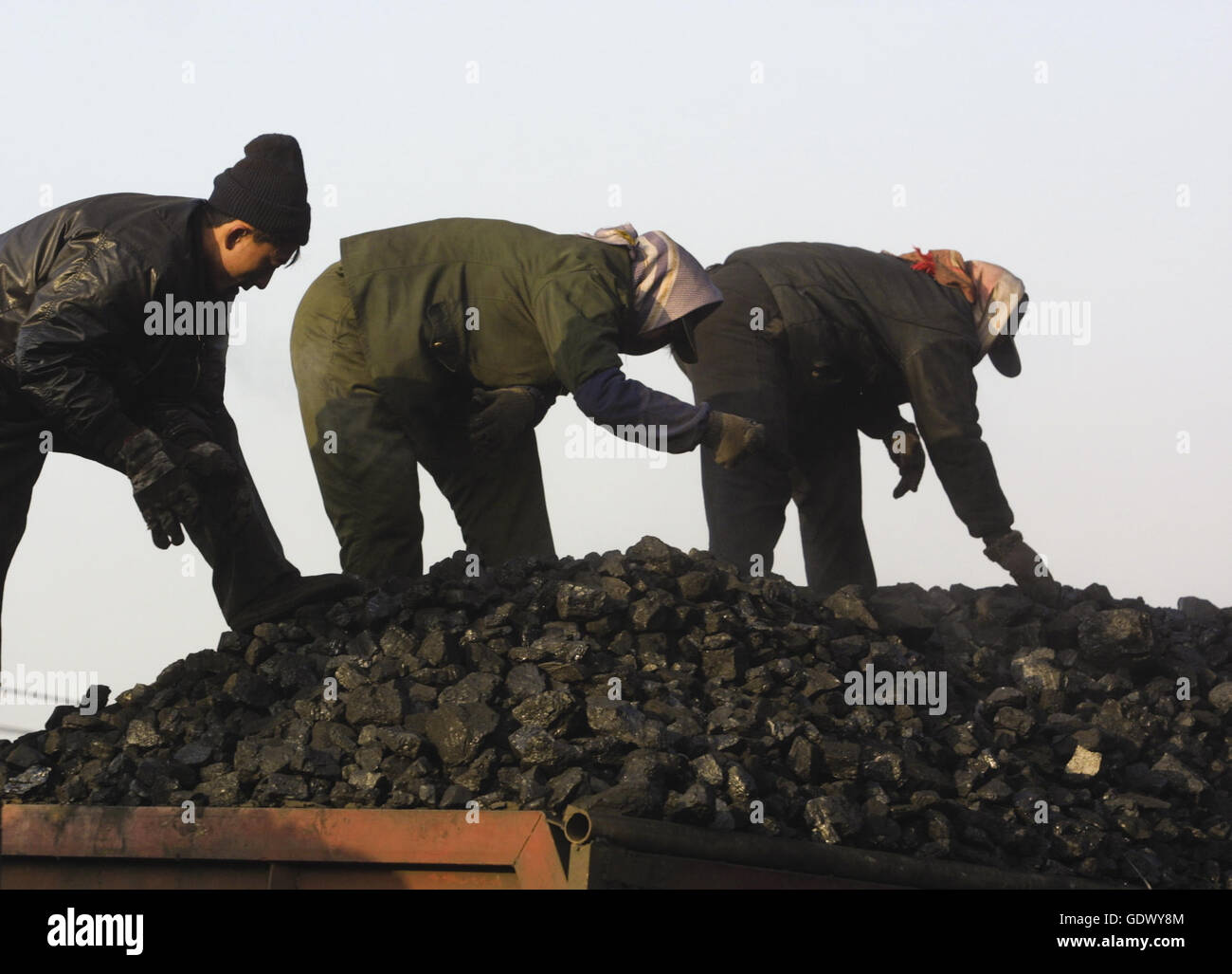 Workers sort coal bricks at a small coal mine Stock Photo - Alamy