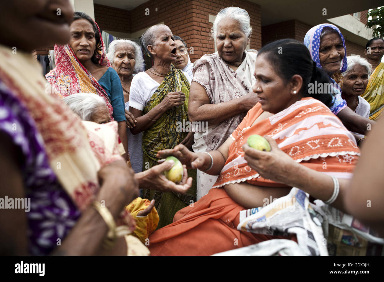 Giving out mango Stock Photo - Alamy