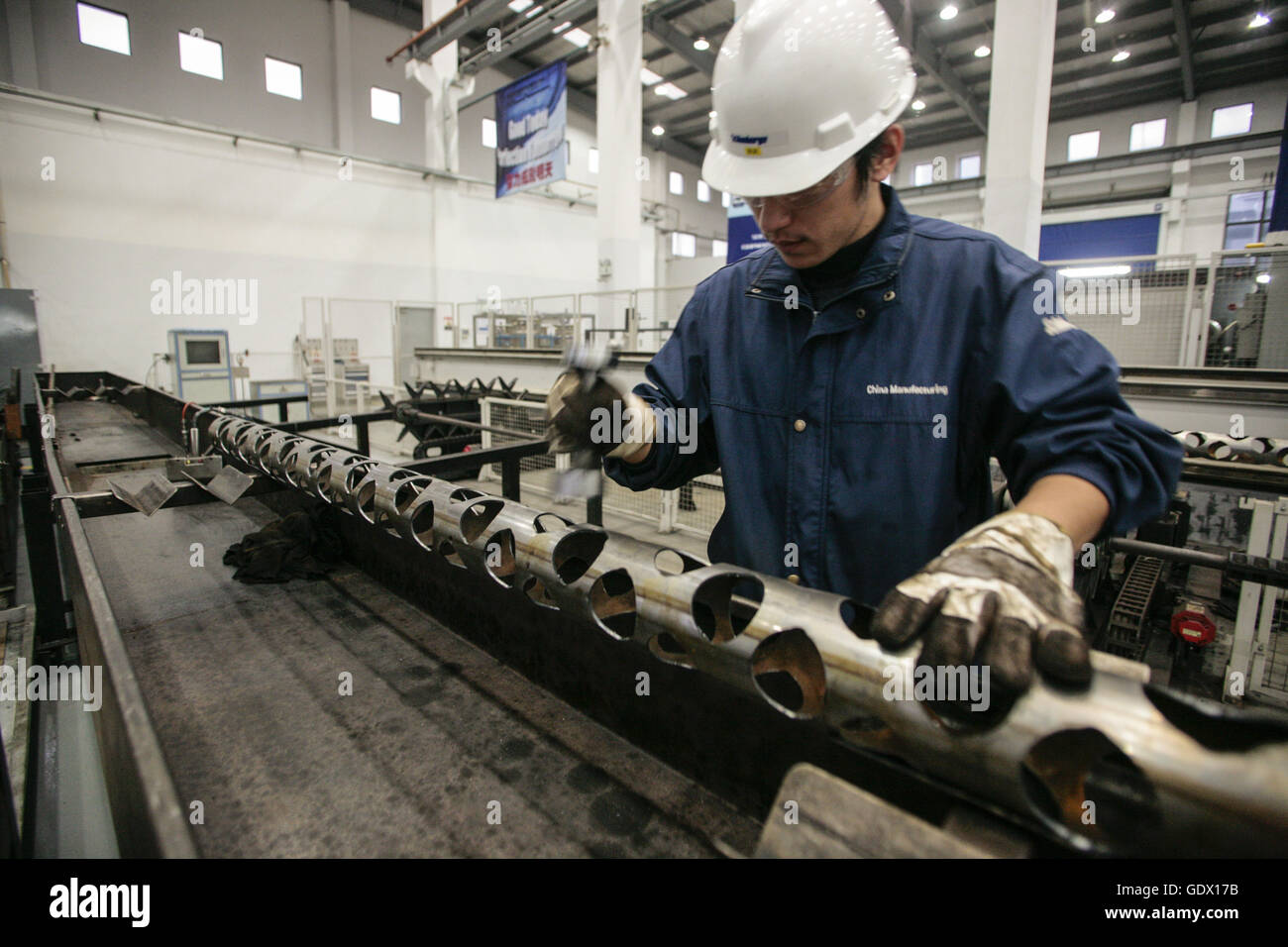 Workers work at a drilling pipe production line in a Schlumberger plant ...
