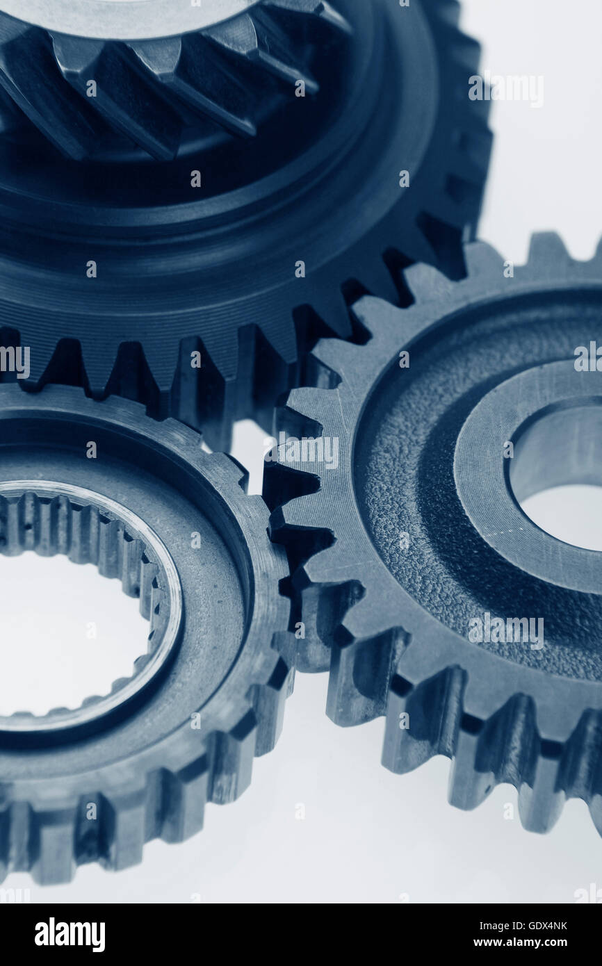 Metal cog gears joining together Stock Photo - Alamy