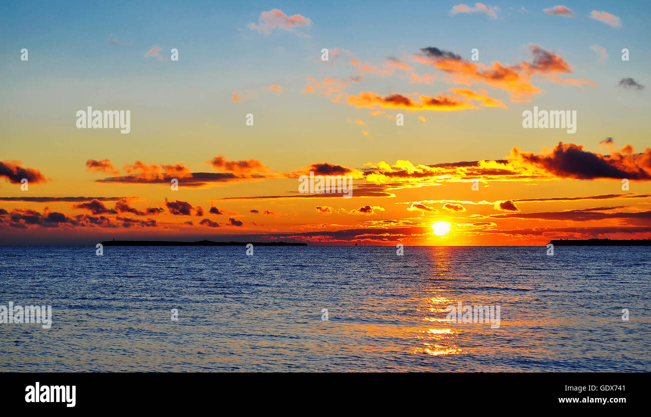 beautiful seascape with a remote island and iridescent clouds Stock ...