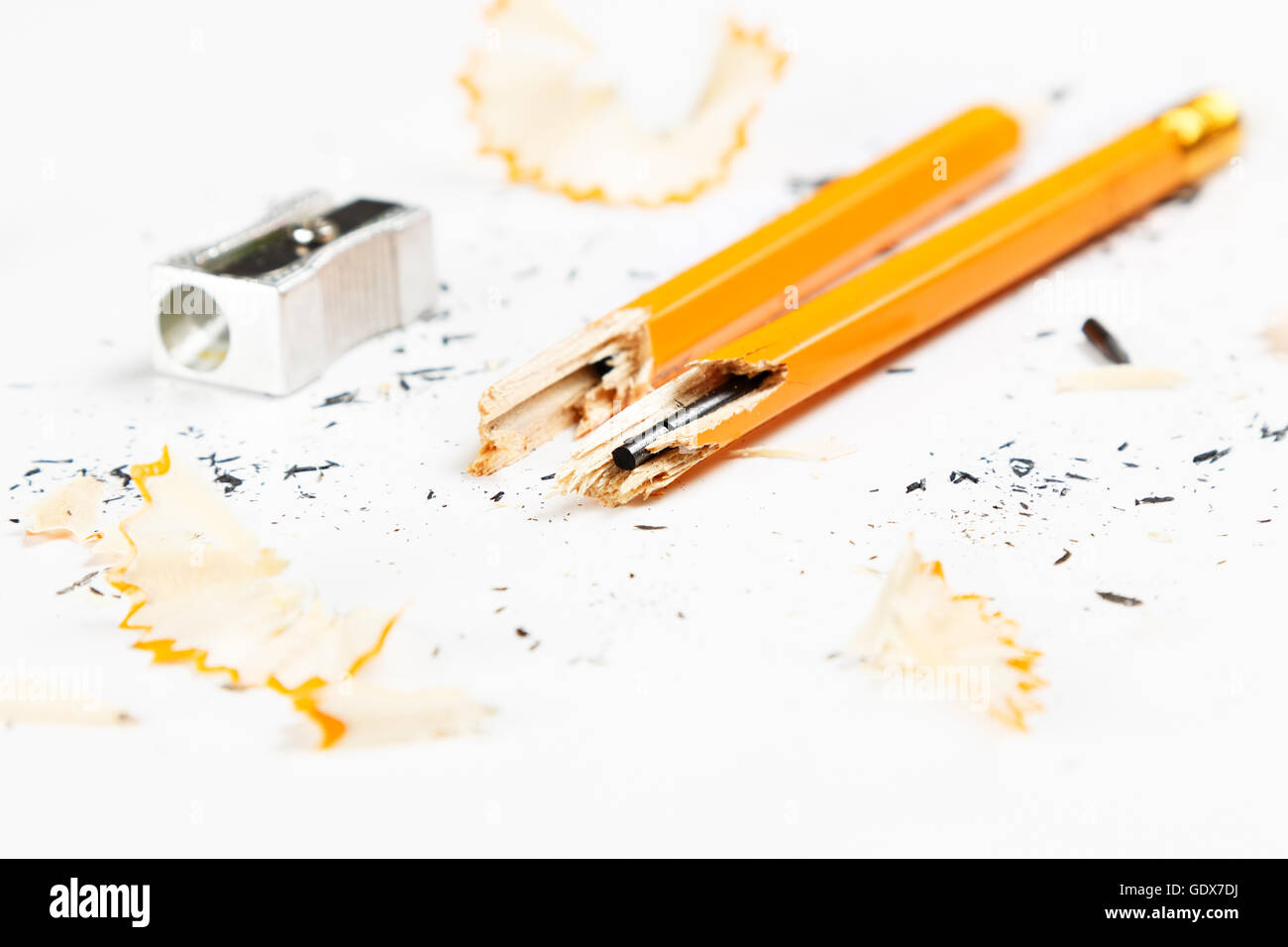 Pencil, metal sharpener and pencil shavings on white background ...