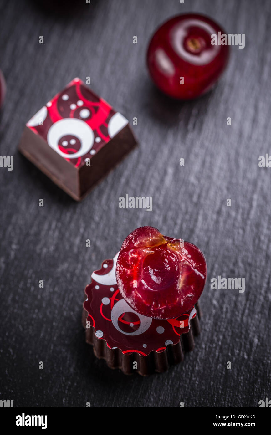 Sweet chocolate pralines with cherry on black background Stock Photo ...