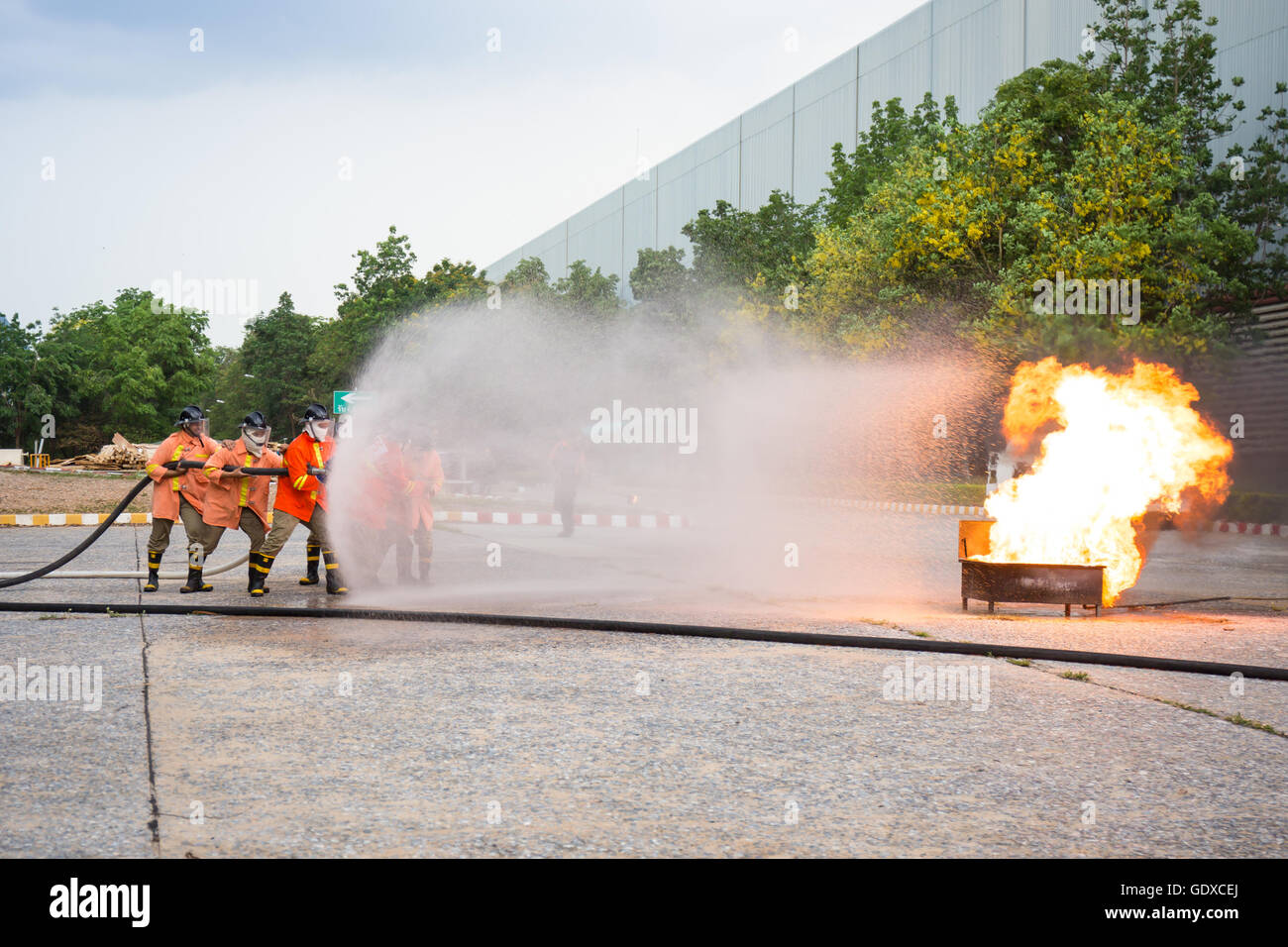 Firefighters attack fire during a training exercise Stock Photo - Alamy