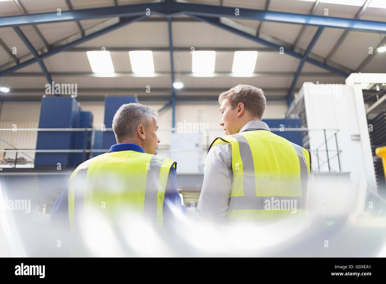 Supervisor and worker talking in steel factory Stock Photo - Alamy
