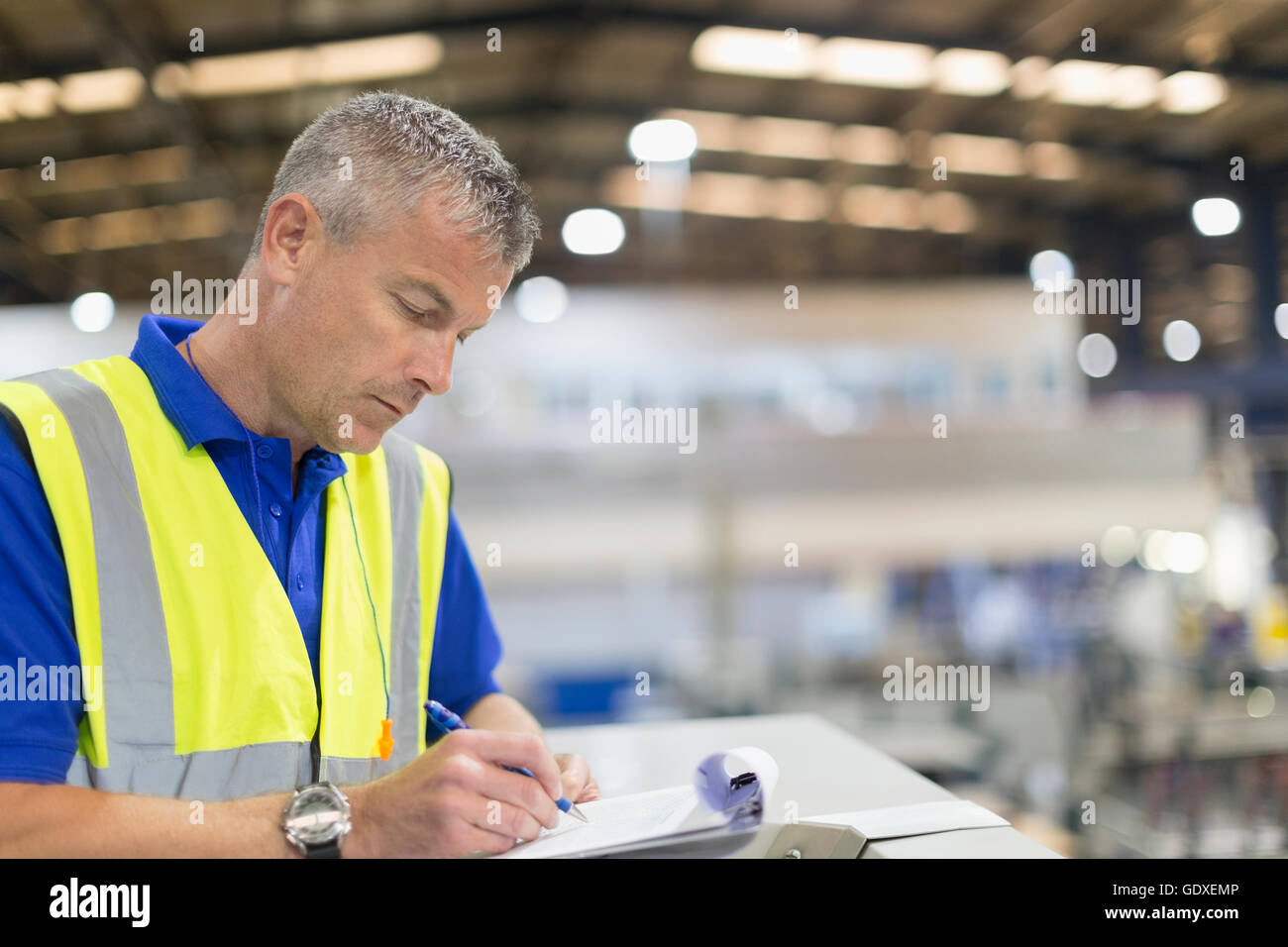 Supervisor writing on clipboard in steel factory Stock Photo - Alamy