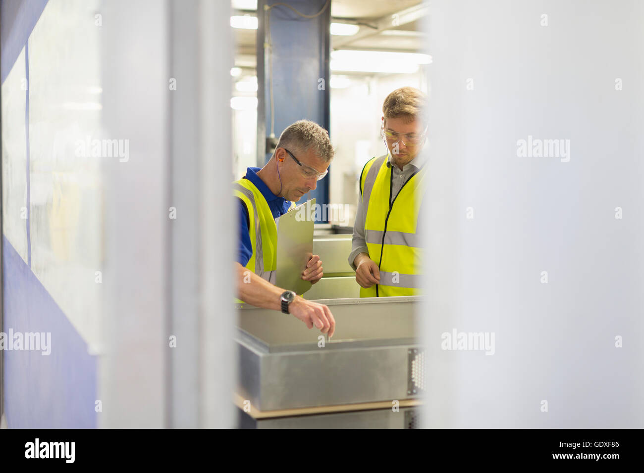 Supervisor and worker inspecting pieces in steel factory Stock Photo ...