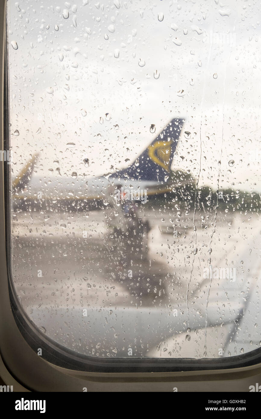 Raindrops on the window of a ryanair plane on the tarmac awaiting ...