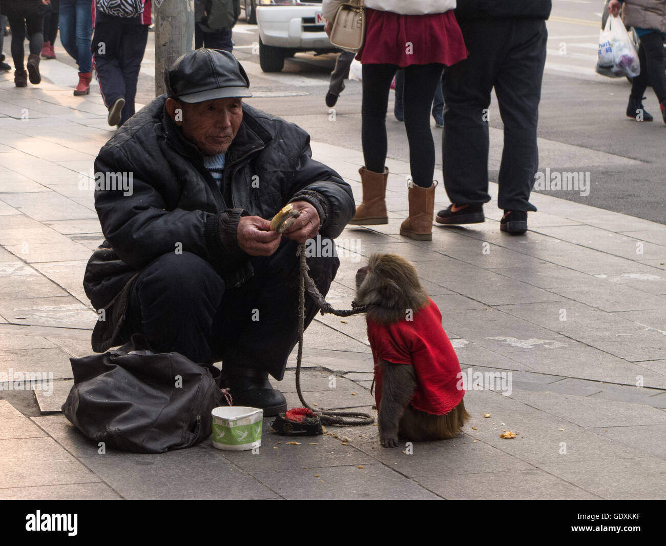 A man carry a monkey to beg on a street Stock Photo - Alamy