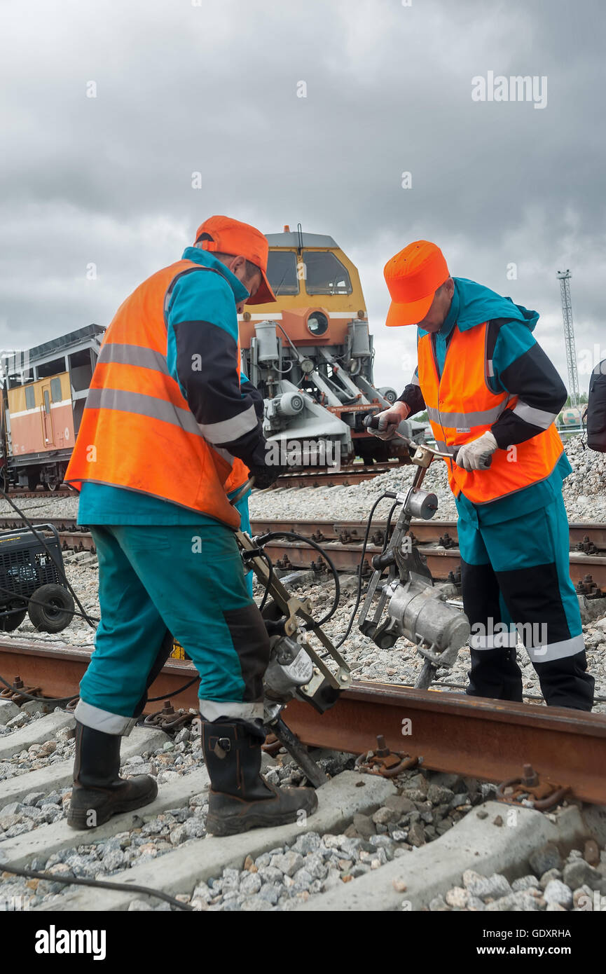 Railway workers repairing rail Stock Photo - Alamy