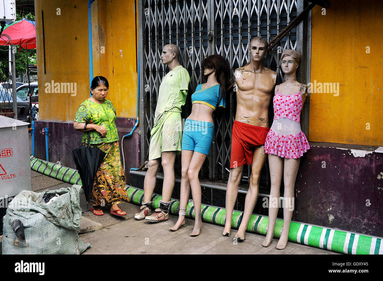 2015 a woman walks by manikins in yangons downtown district hi-res stock photography and images ...
