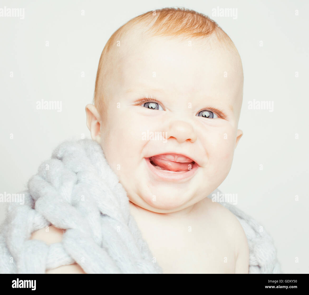 little cute red head baby in scarf all over him close up isolated ...