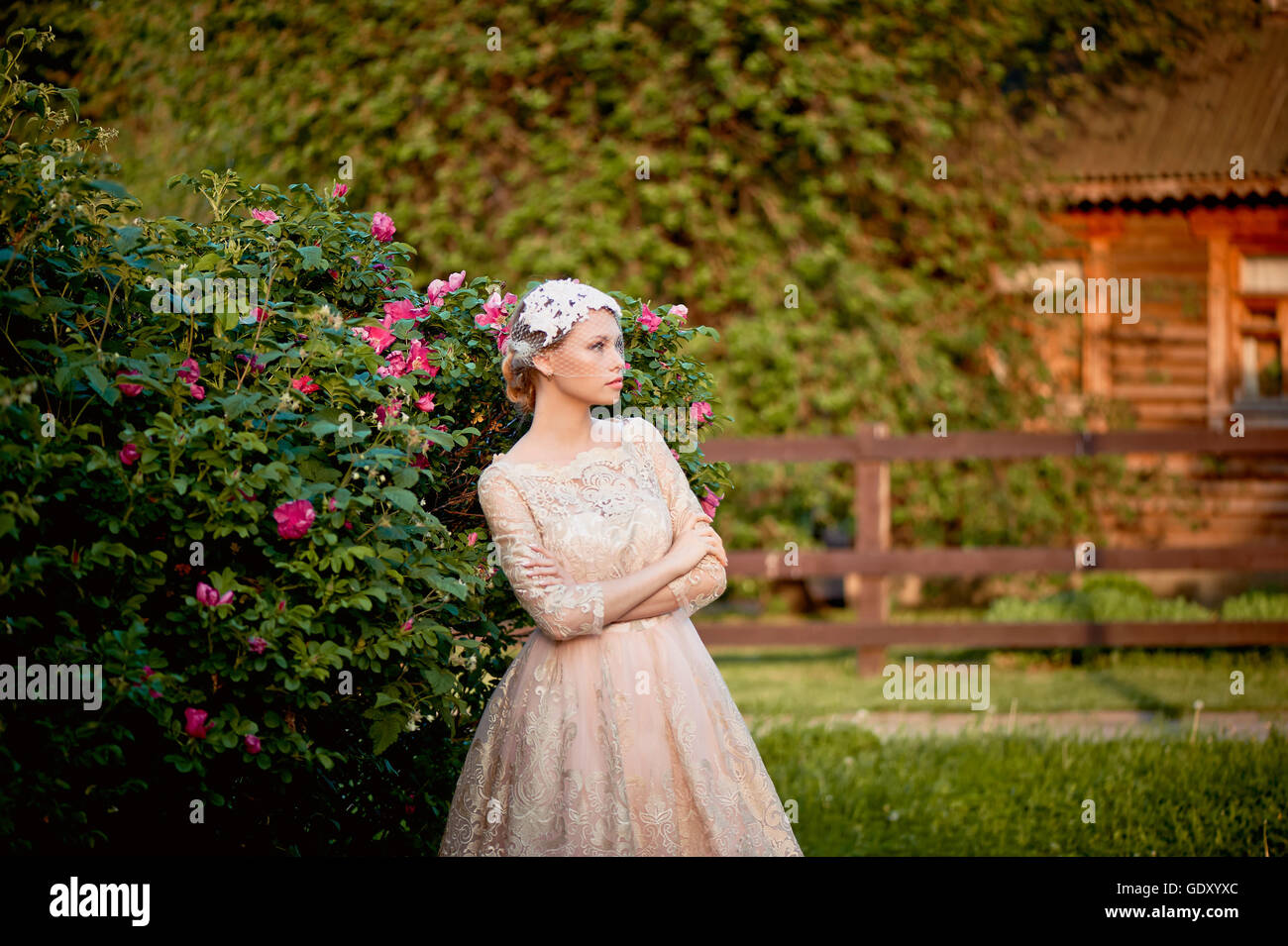 Pretty tender blonde in a lace cream dress against the background of ...