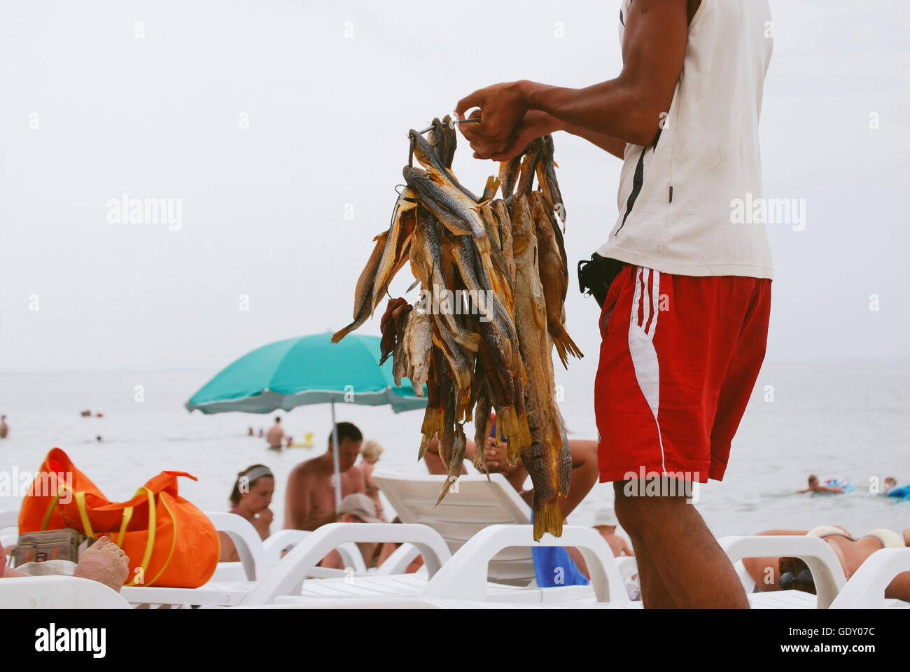 Fish seller is carrying fish on the beach in Crimea, Yevpatoria ...