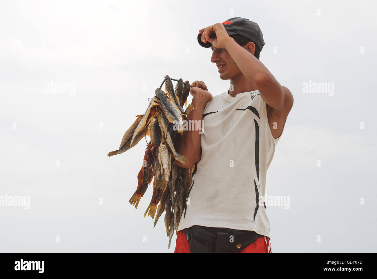Fish seller is carrying fish on the beach in Crimea, Yevpatoria ...