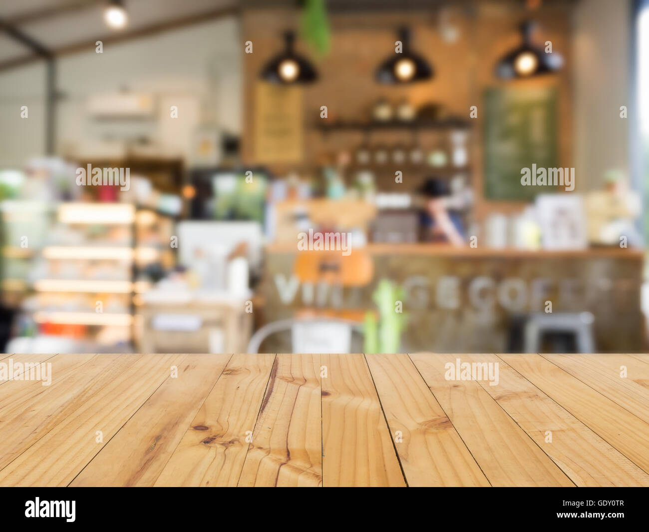 Wooden table with blurred coffee shop background Stock Photo - Alamy