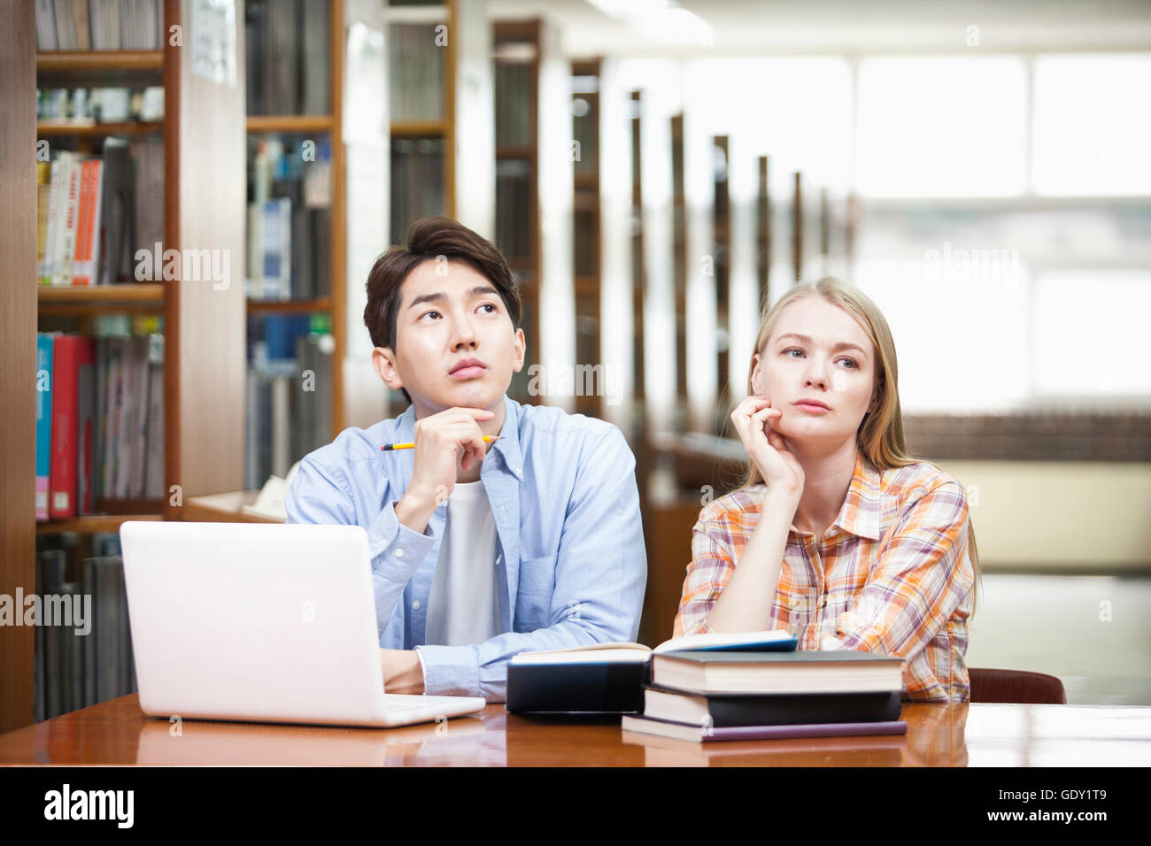 Portrait of young college students worried during studying at library ...