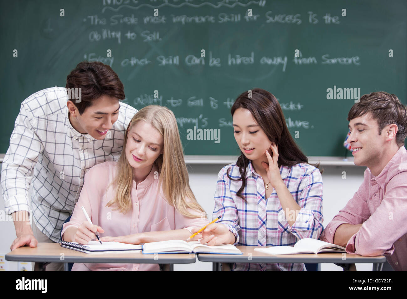Four college students studying at classroom Stock Photo - Alamy