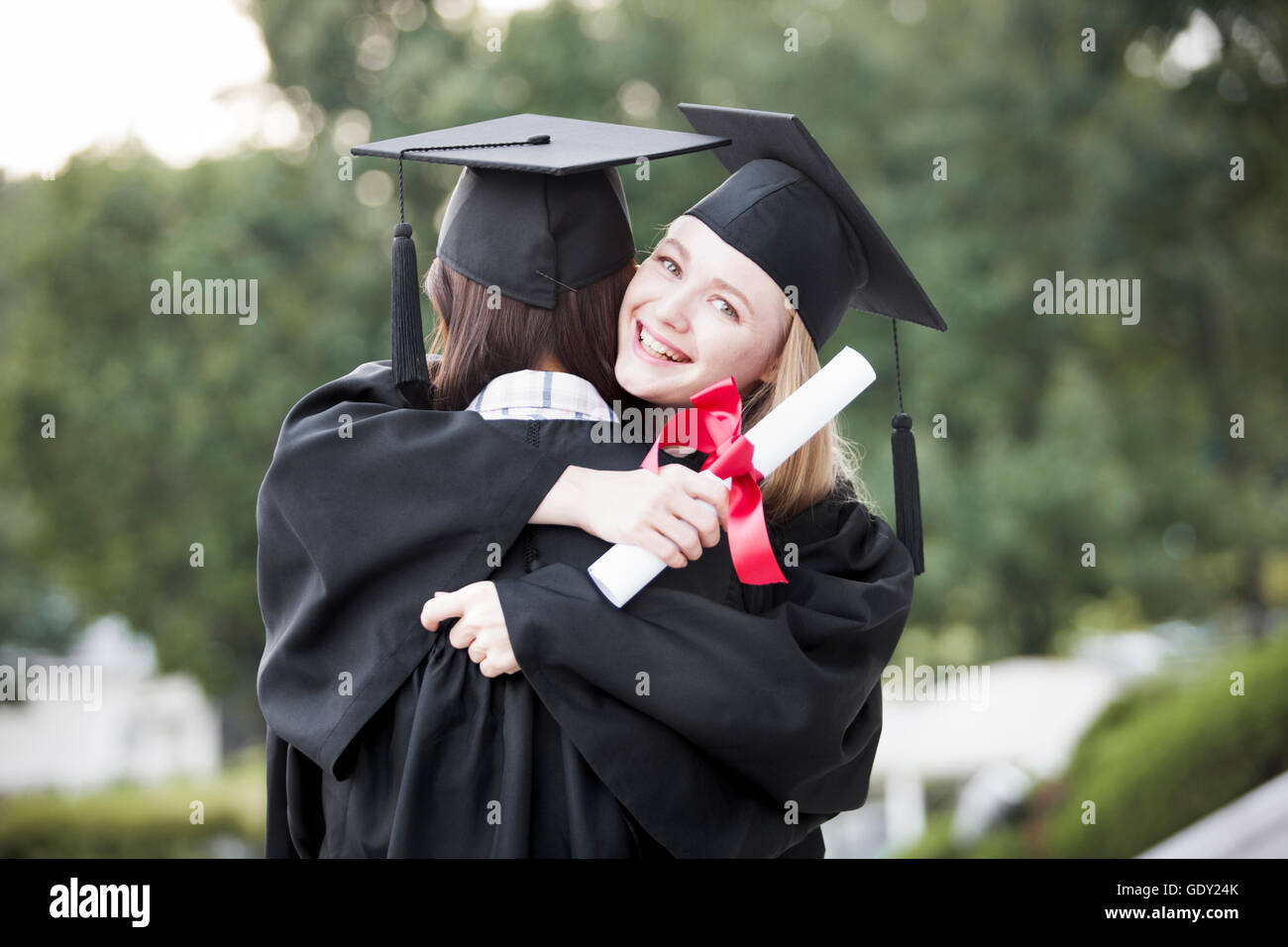 Two happy college graduates hugging Stock Photo - Alamy