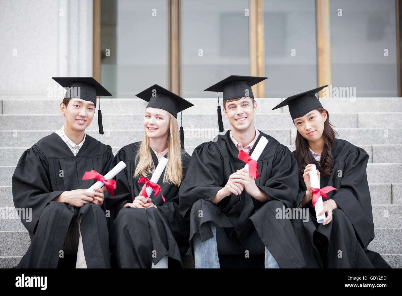 Four smiling college graduates with their certifications Stock Photo ...