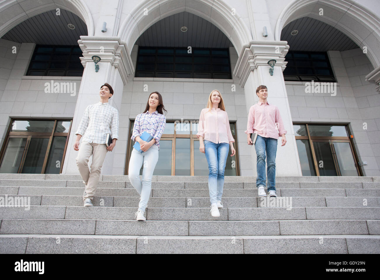 Four smiling global college students going downstairs at campus Stock ...