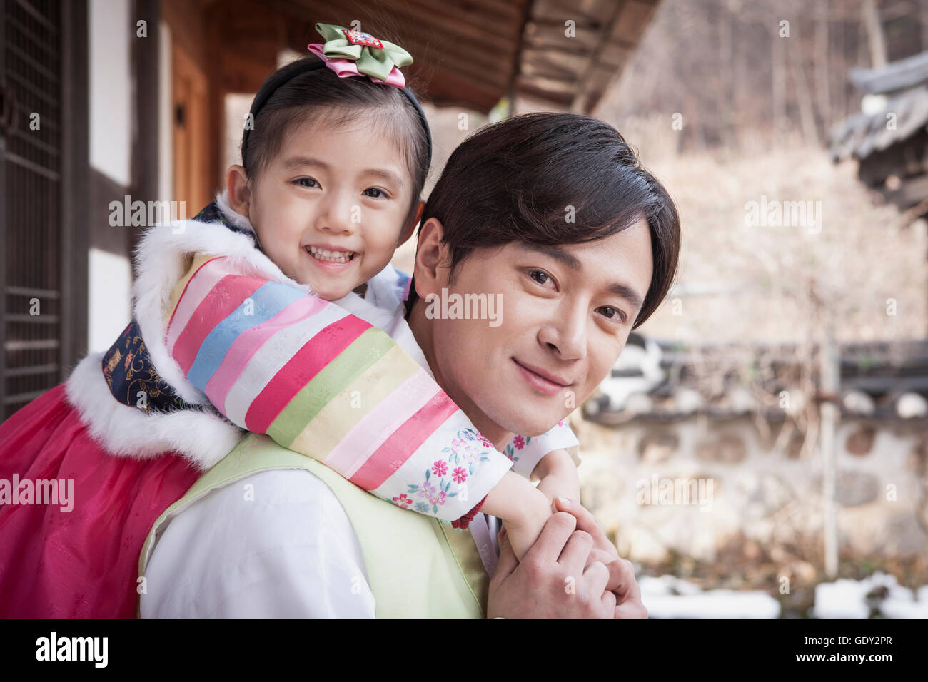 Portrait of smiling daughter and father in traditional Korean clothes ...