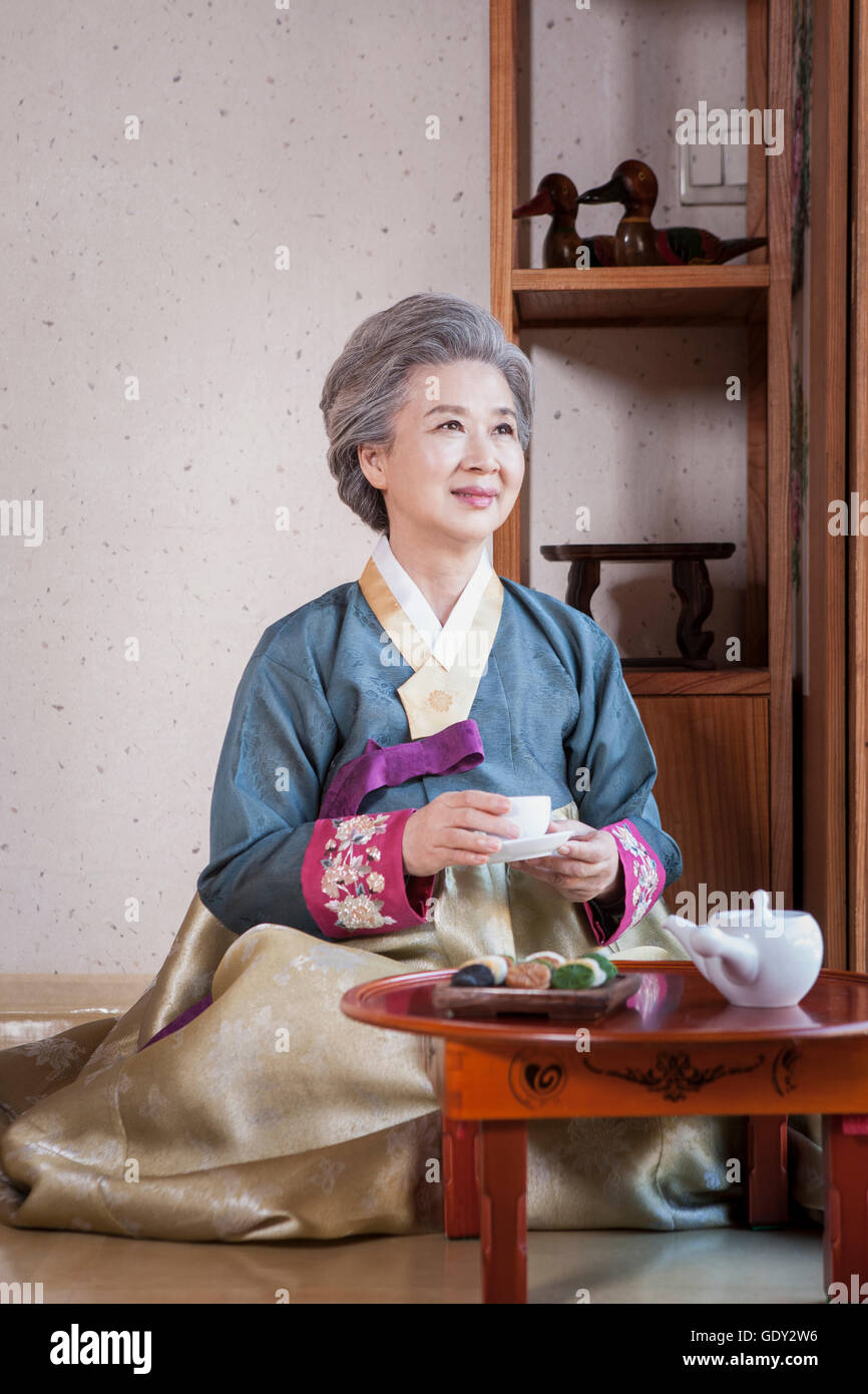 Smiling old woman in traditional Korean clothes having teatime Stock ...