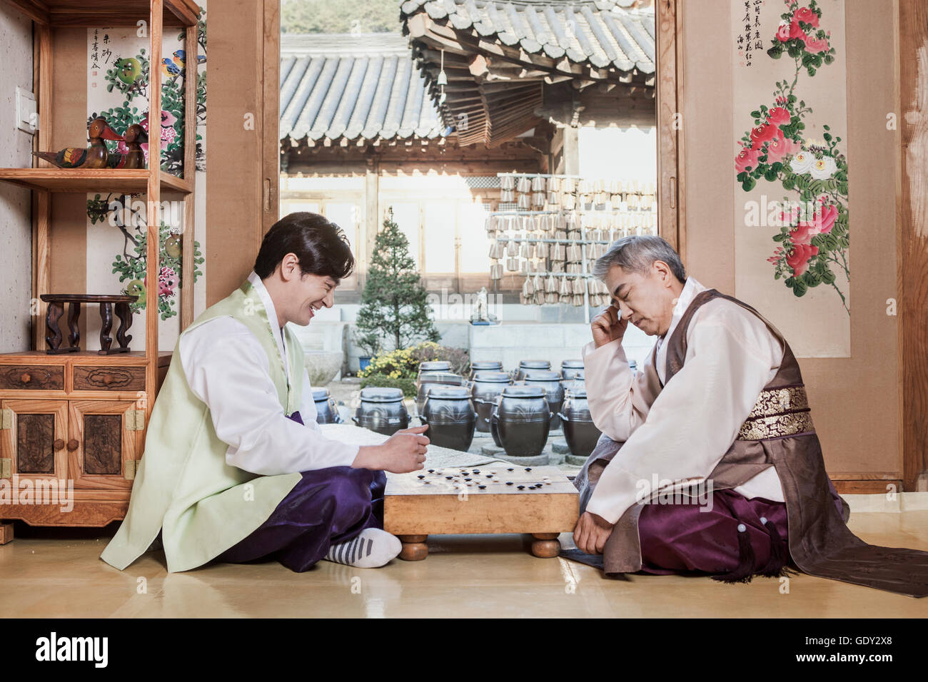 Side view of young man and old man in traditional Korean clothes ...