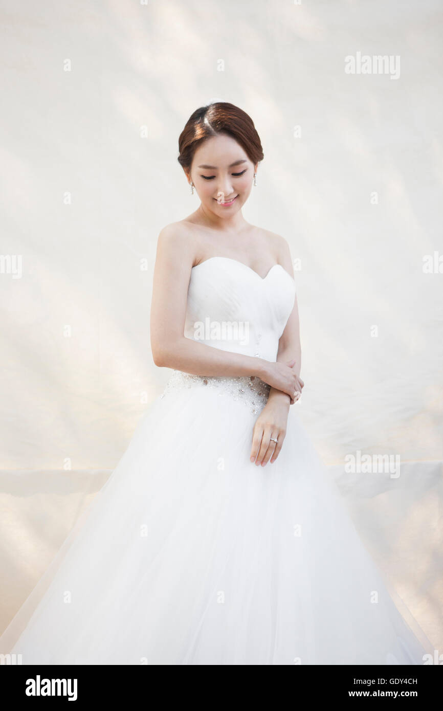 Smiling bride standing looking down Stock Photo - Alamy