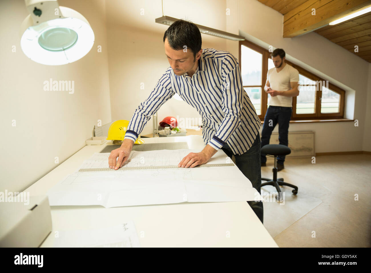 Architect working on blueprint in office, Bavaria, Germany Stock Photo ...