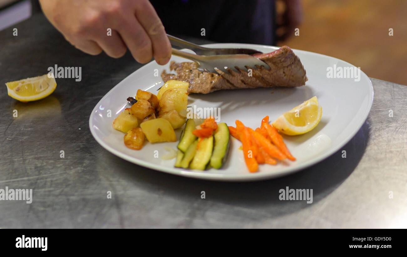 Preparing a dish of meat in the kitchen of a restaurant Stock Photo - Alamy