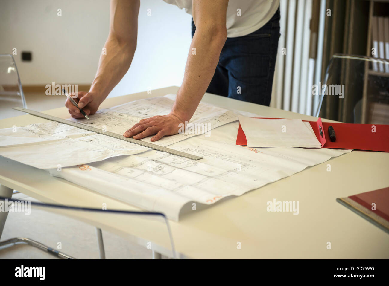 Midsection view of an architect making a blueprint in the office ...