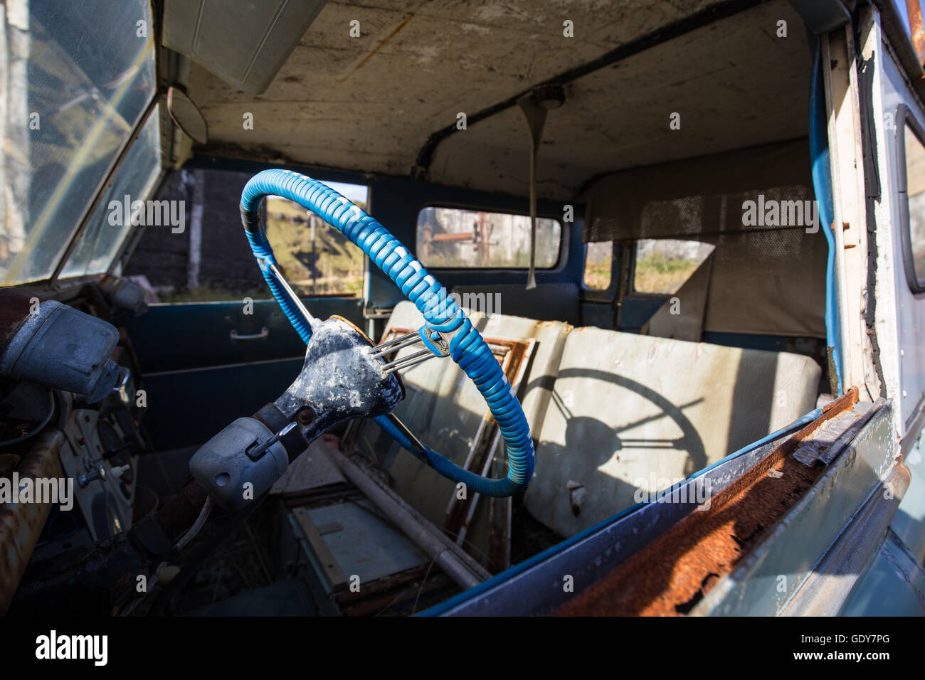 Interior cabin of an old broken car, torn up seats and exposed wires ...
