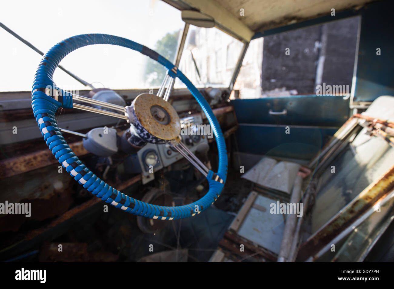 Interior cabin of an old broken car, torn up seats and exposed wires ...