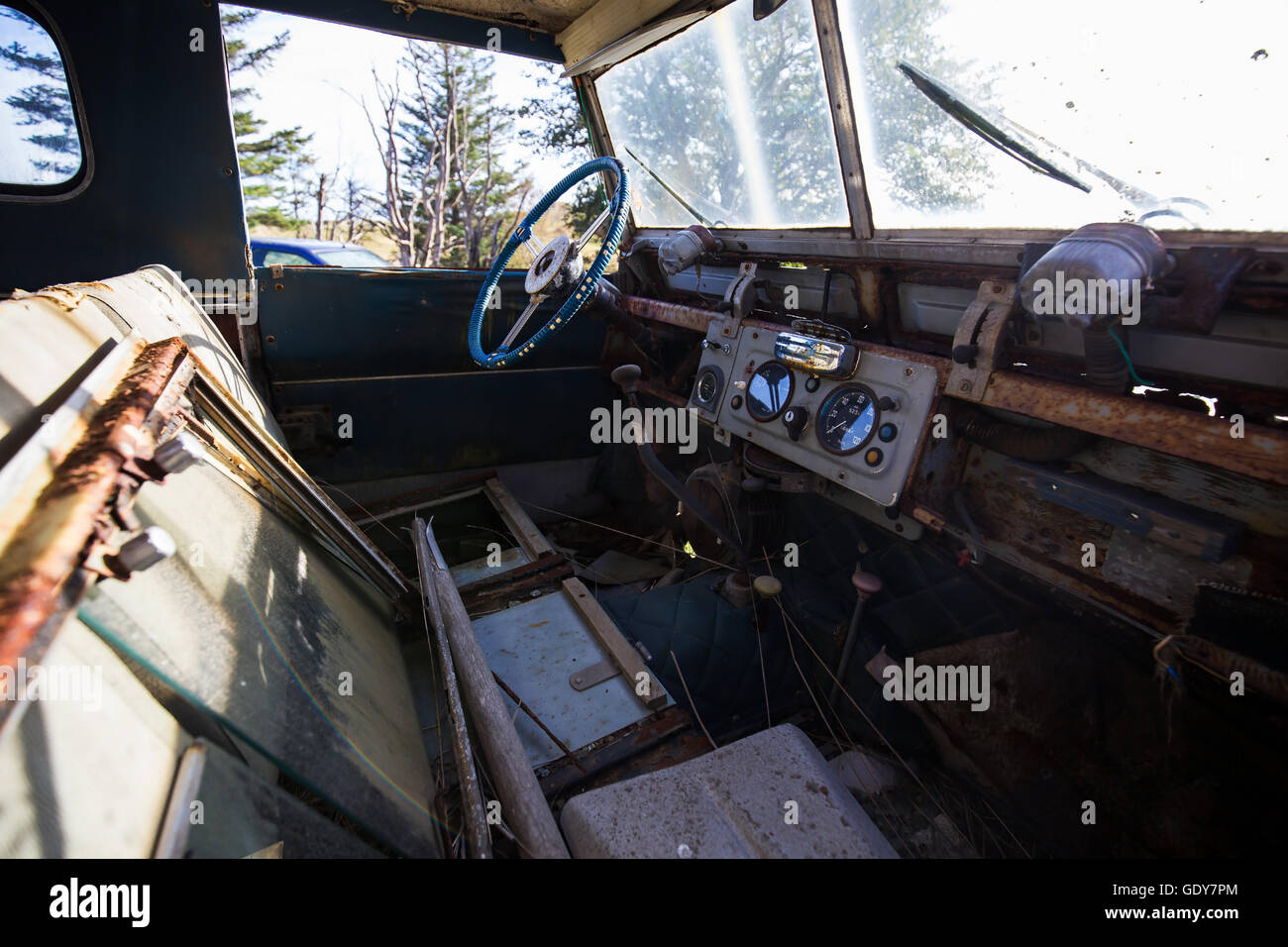 Interior cabin of an old broken car, torn up seats and exposed wires ...