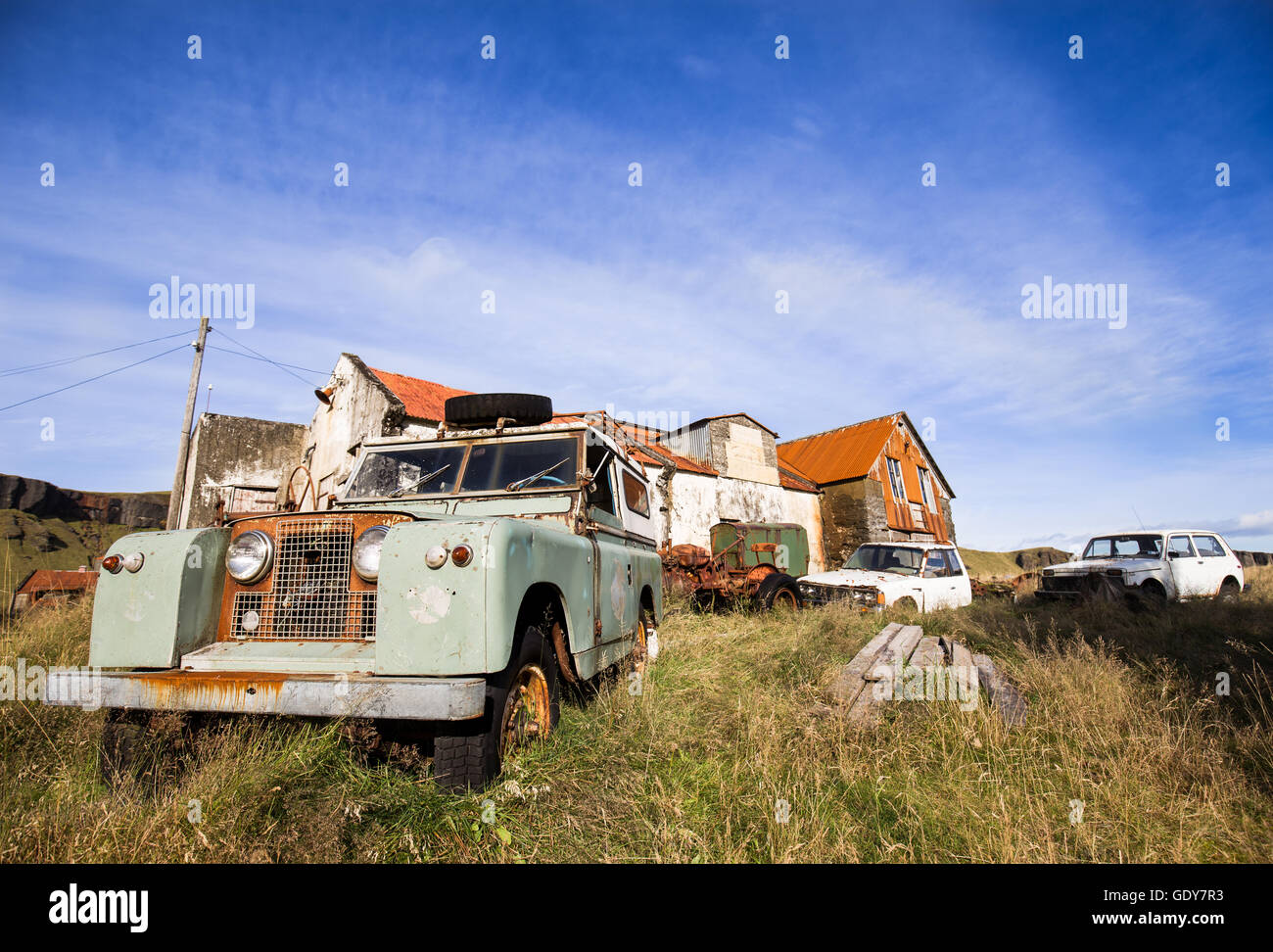 Car junkyard at a farm in Iceland, run down cars and run down buildings ...